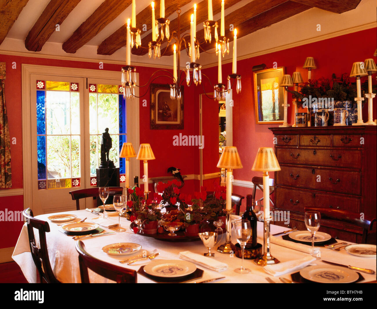 Lighted candles in candle chandelier above table set for lunch with ...