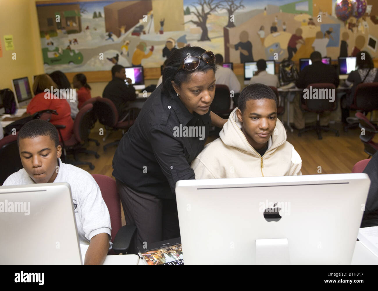 Computer specialist works with students in the computer lab of the ...