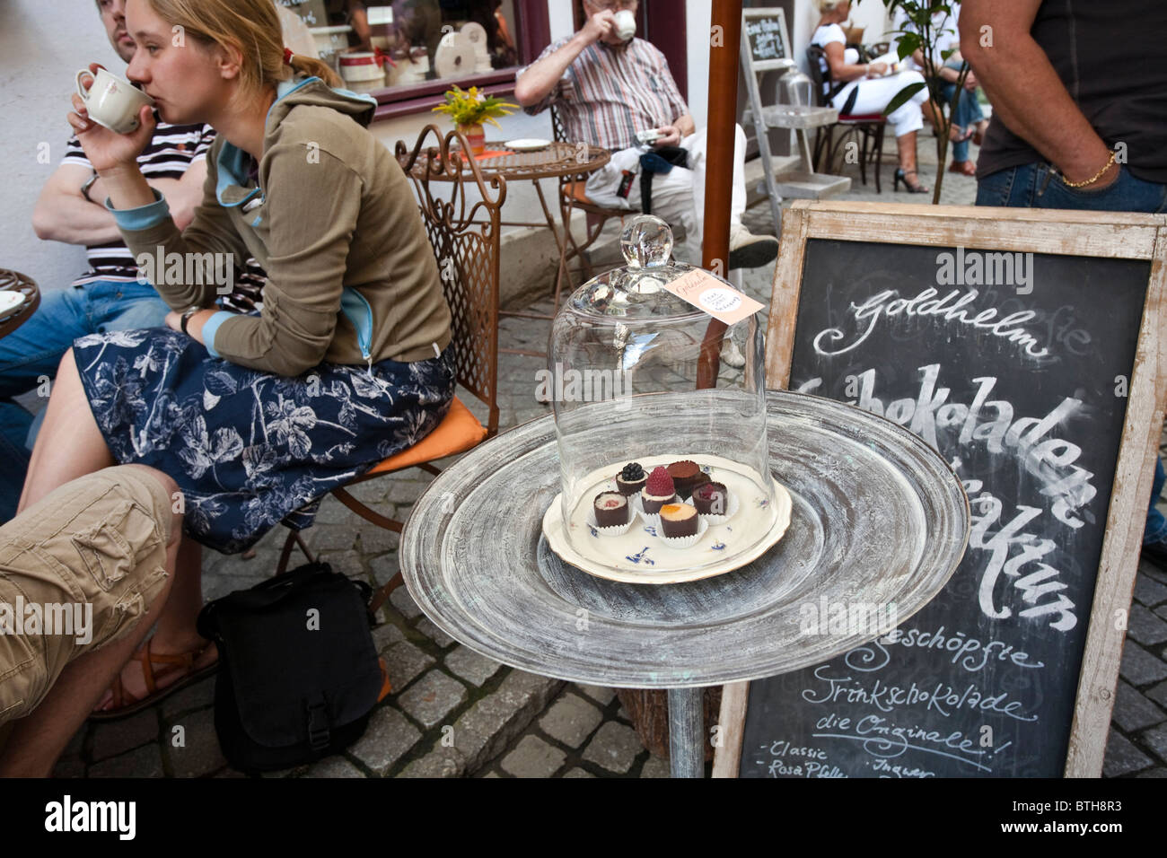People at a German café near display of chocolate truffles. Chocolate ...