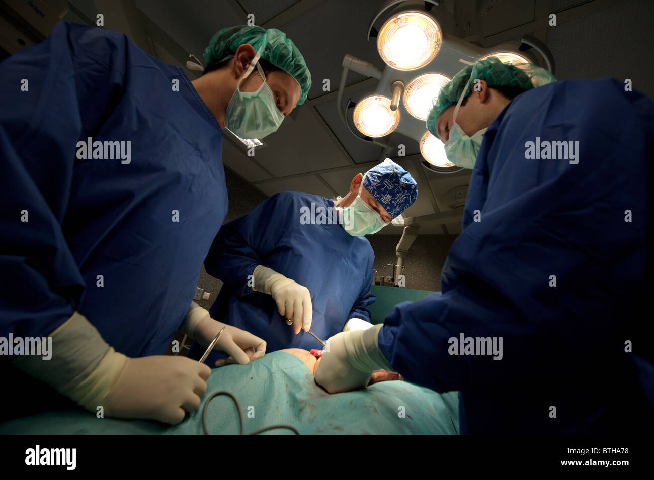 Doctors performing surgery in operating room Stock Photo - Alamy