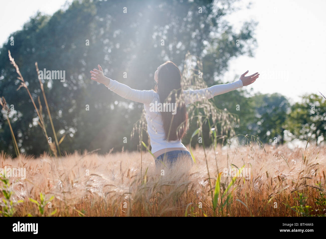 Woman with arms stretched out in wheat field Stock Photo - Alamy