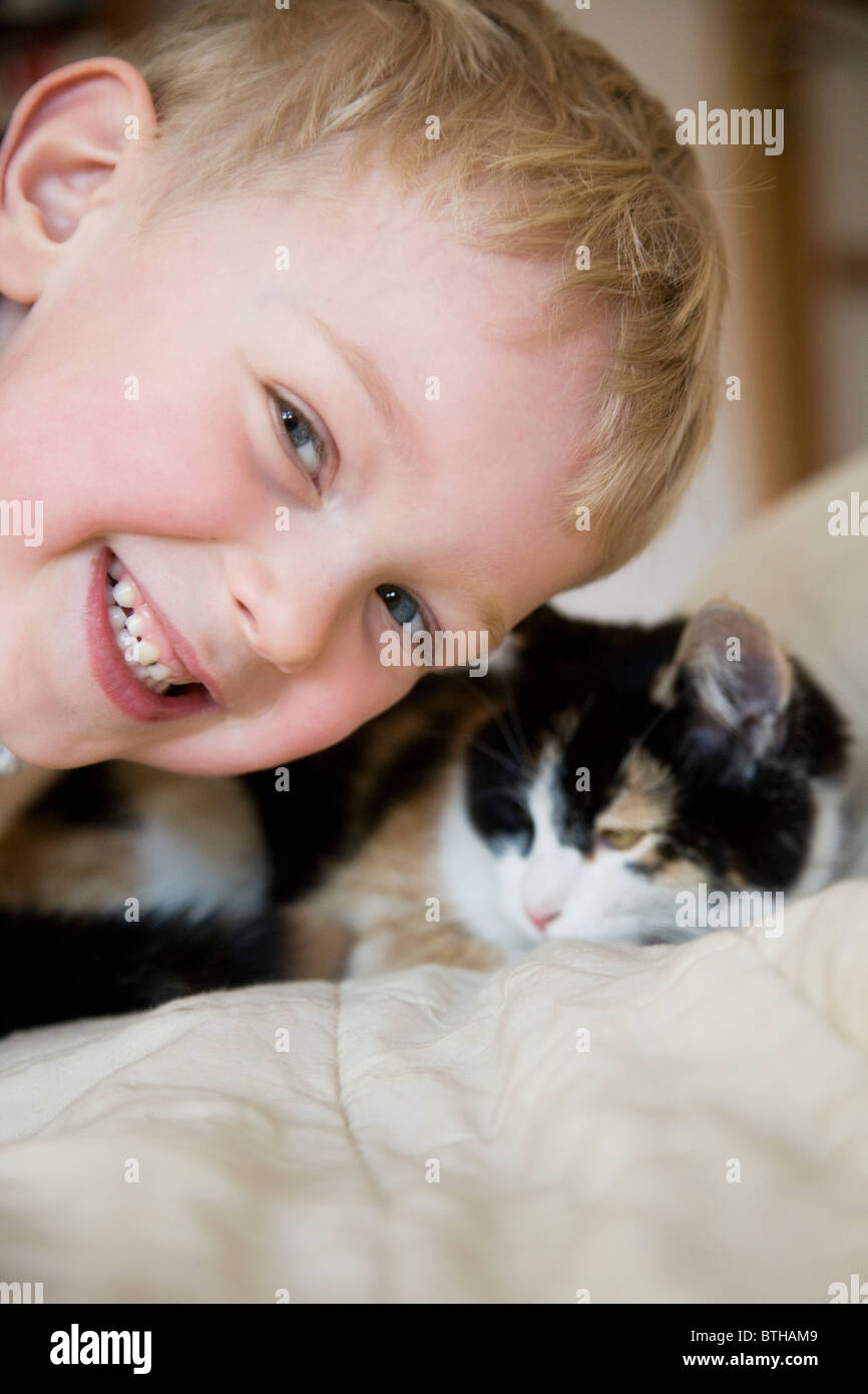 boy playing with cat on bed Stock Photo - Alamy