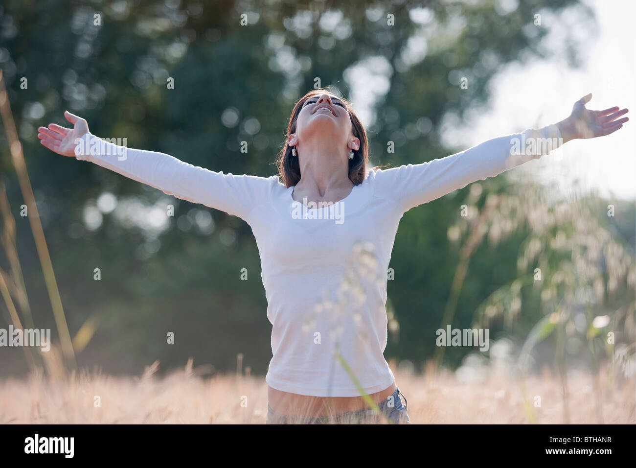Woman with arms stretched out in wheat field Stock Photo - Alamy