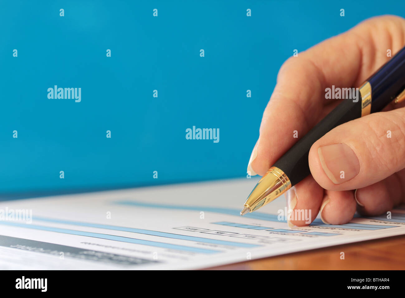 Hand with Pen Signing Form Closeup on Blue Background Stock Photo - Alamy