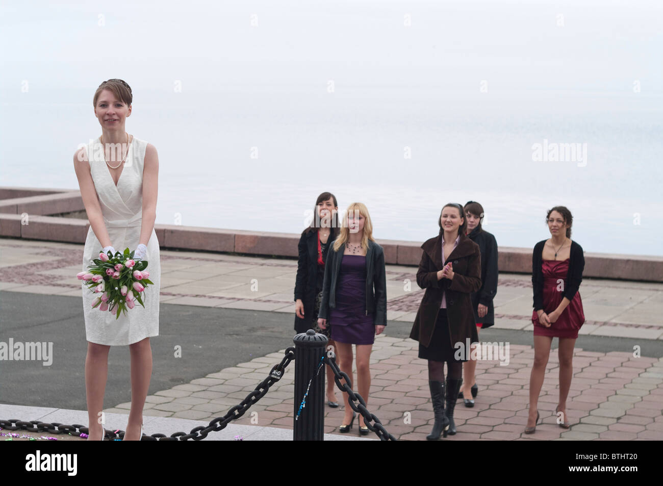 Bride throwing the bouquet back over her back. Bridesmaids catching ...