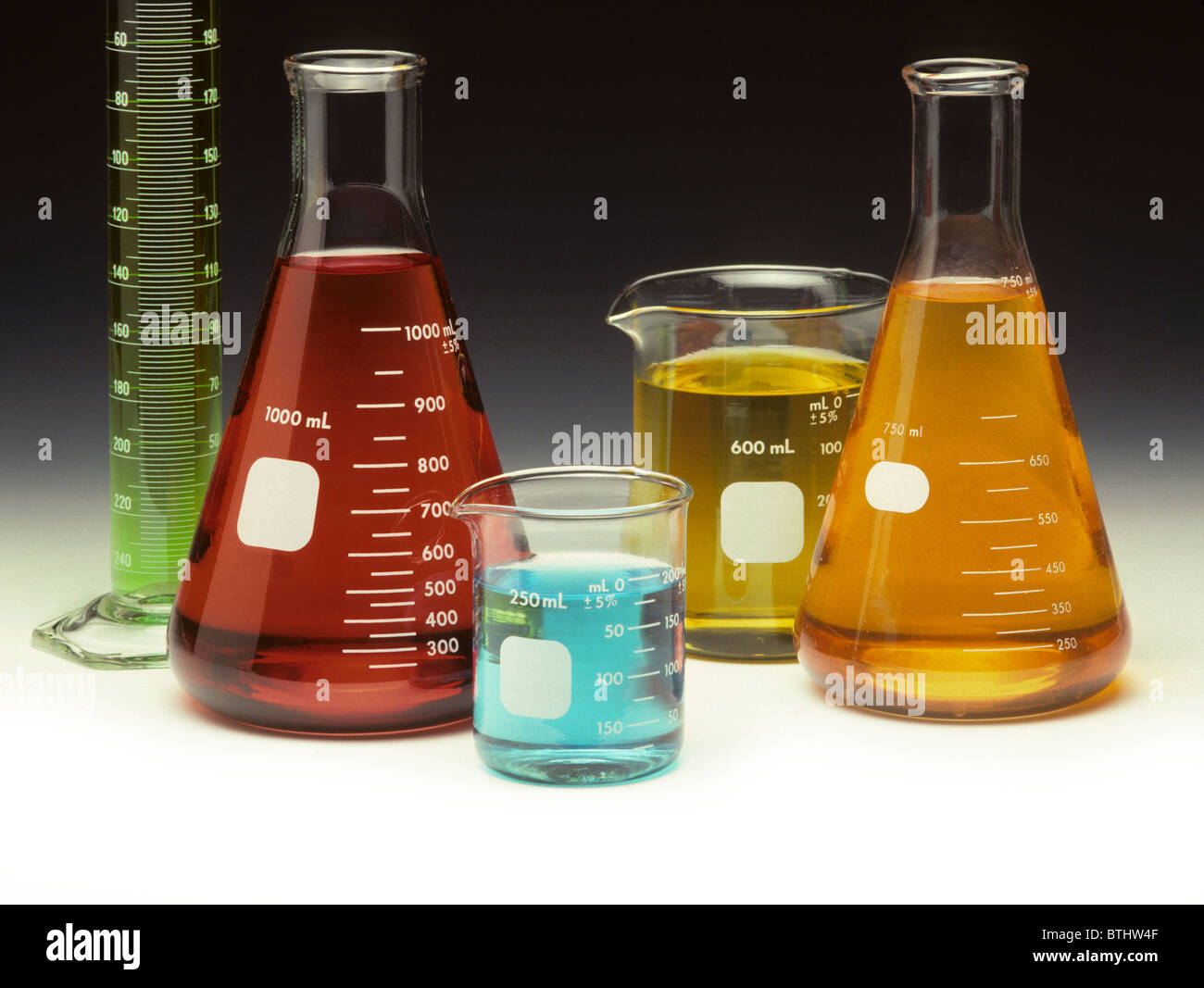 Scientific glassware filled with colored liquids on a graduated ...