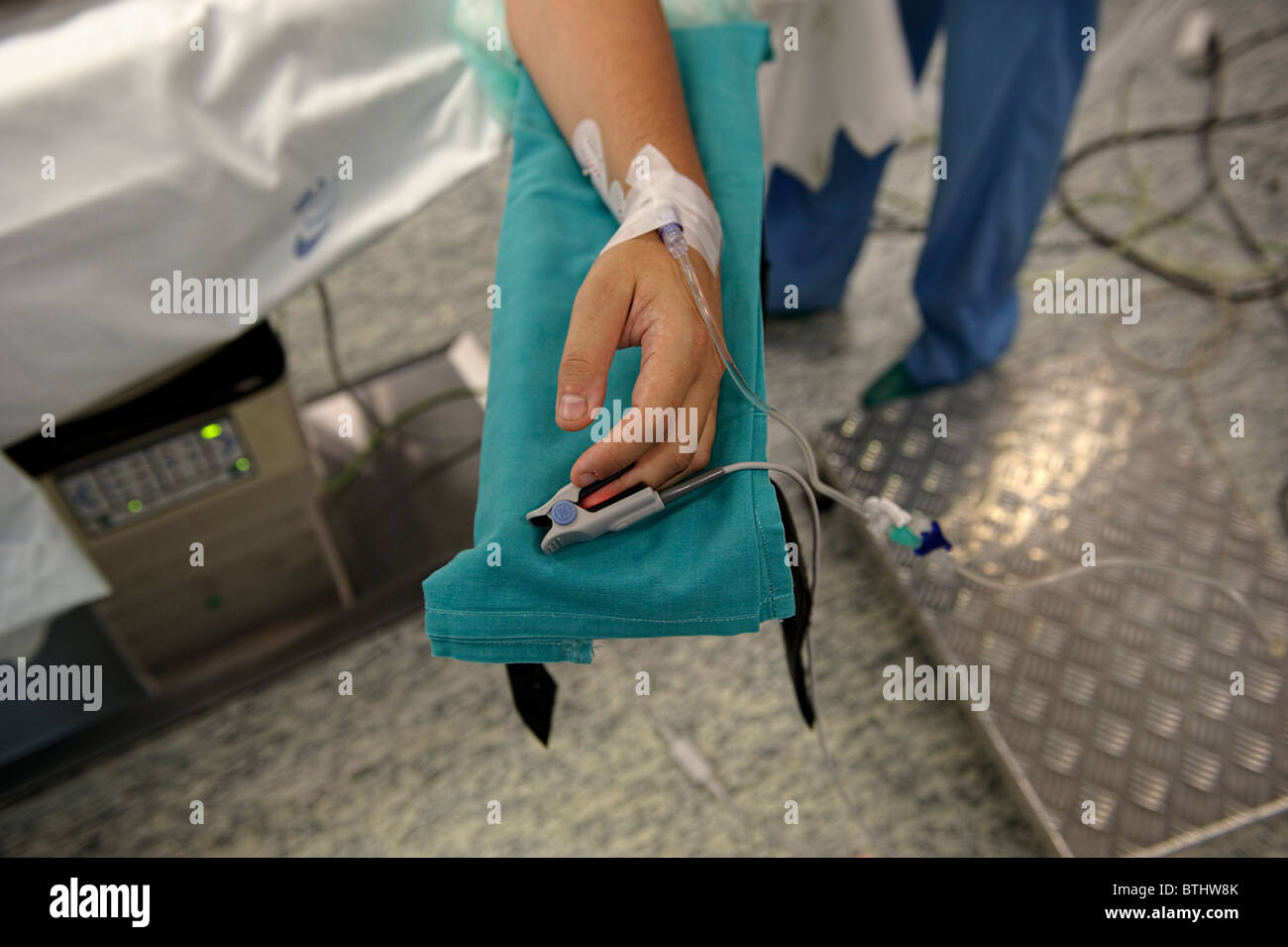 Patient hand with vital signals sensor in preparation for surgery in ...