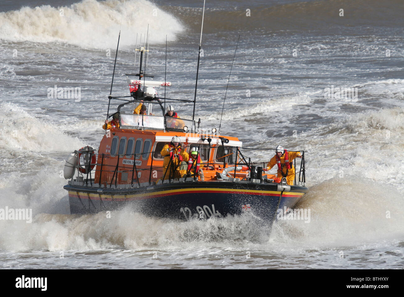 RNLI Mersey class all-weather lifeboat powering through heavy surf off ...