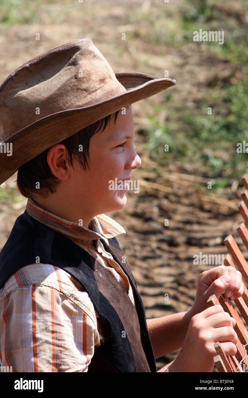A young happy cowboy holding the fence along a rodeo Stock Photo - Alamy
