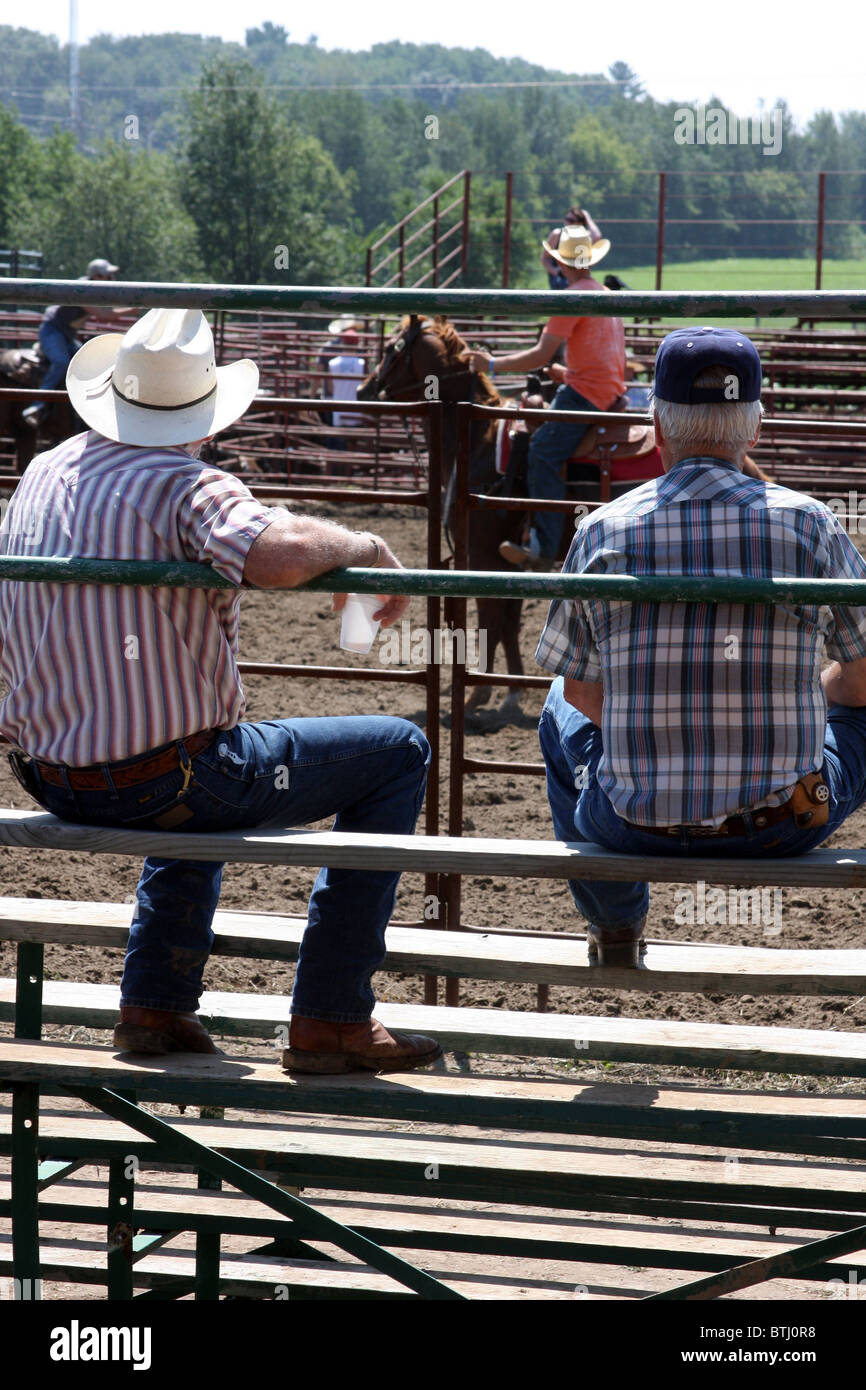 Two older cowboys sitting in the stands watching rodeo competitions in ...