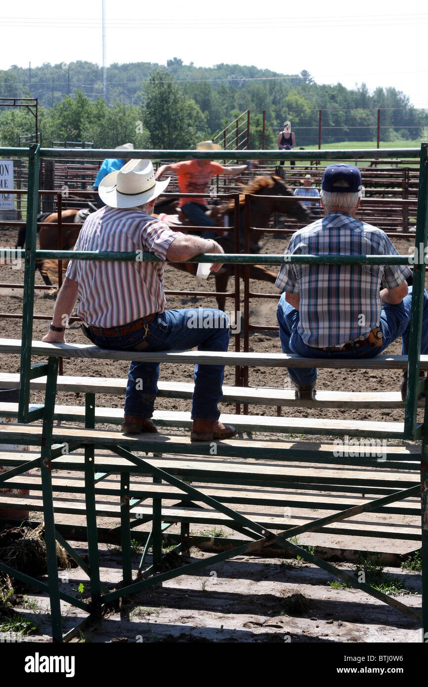Two older cowboys sitting in the stands watching rodeo competitions in ...