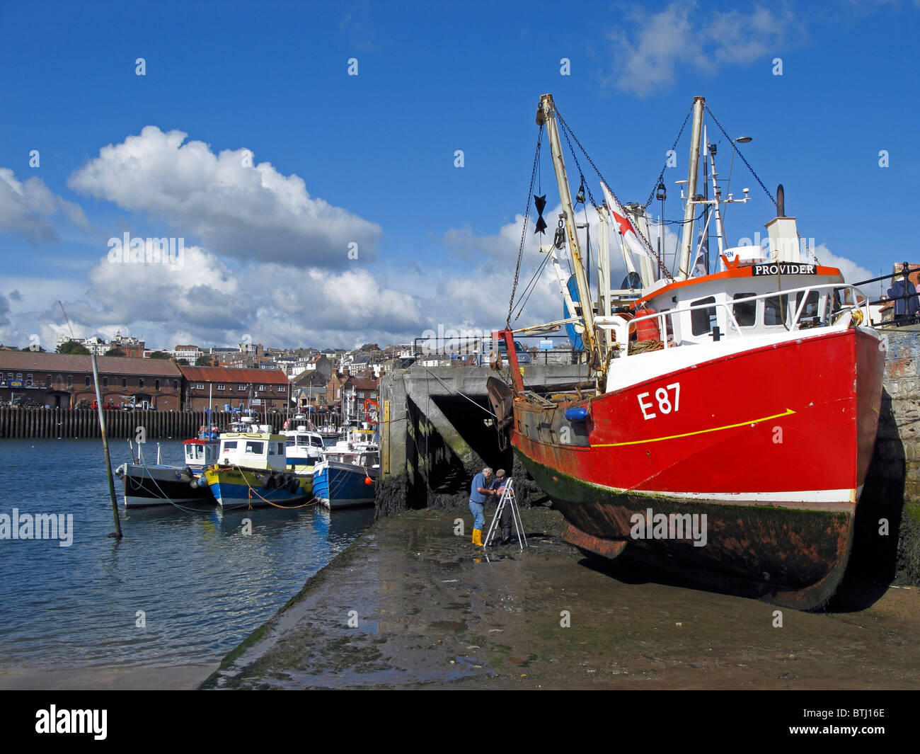 Men working on fishing boat hull, Scarborough harbour Stock Photo - Alamy