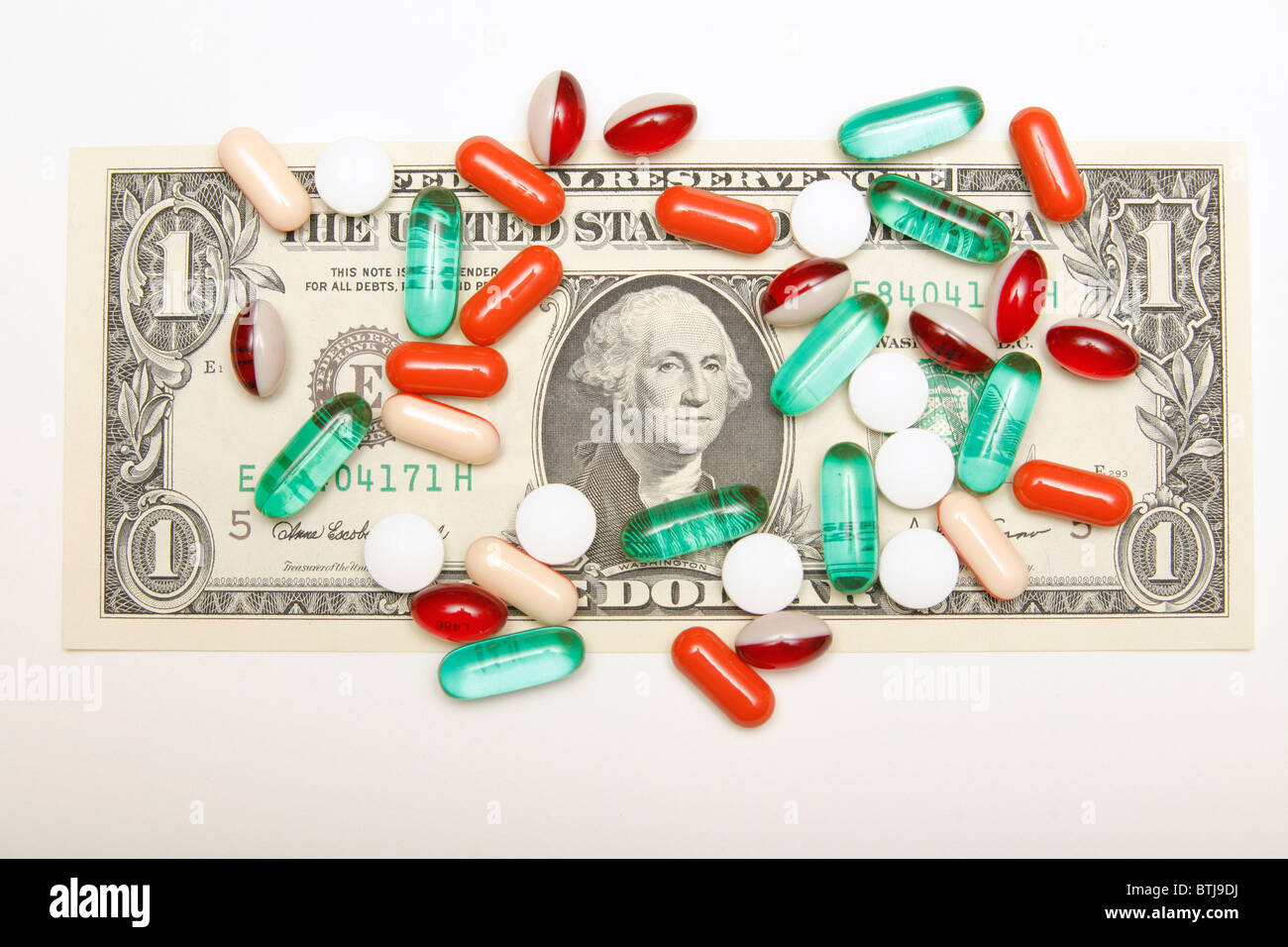 medication pills tablets and softgels on US dollar bill on gray ...