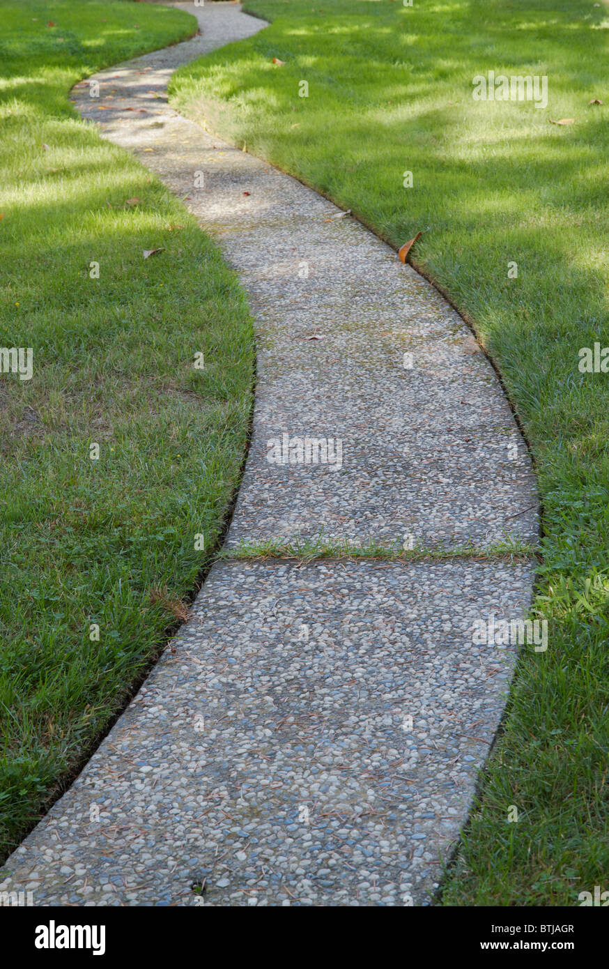 Curved stone and concrete walkway through green grass lawn Stock Photo ...