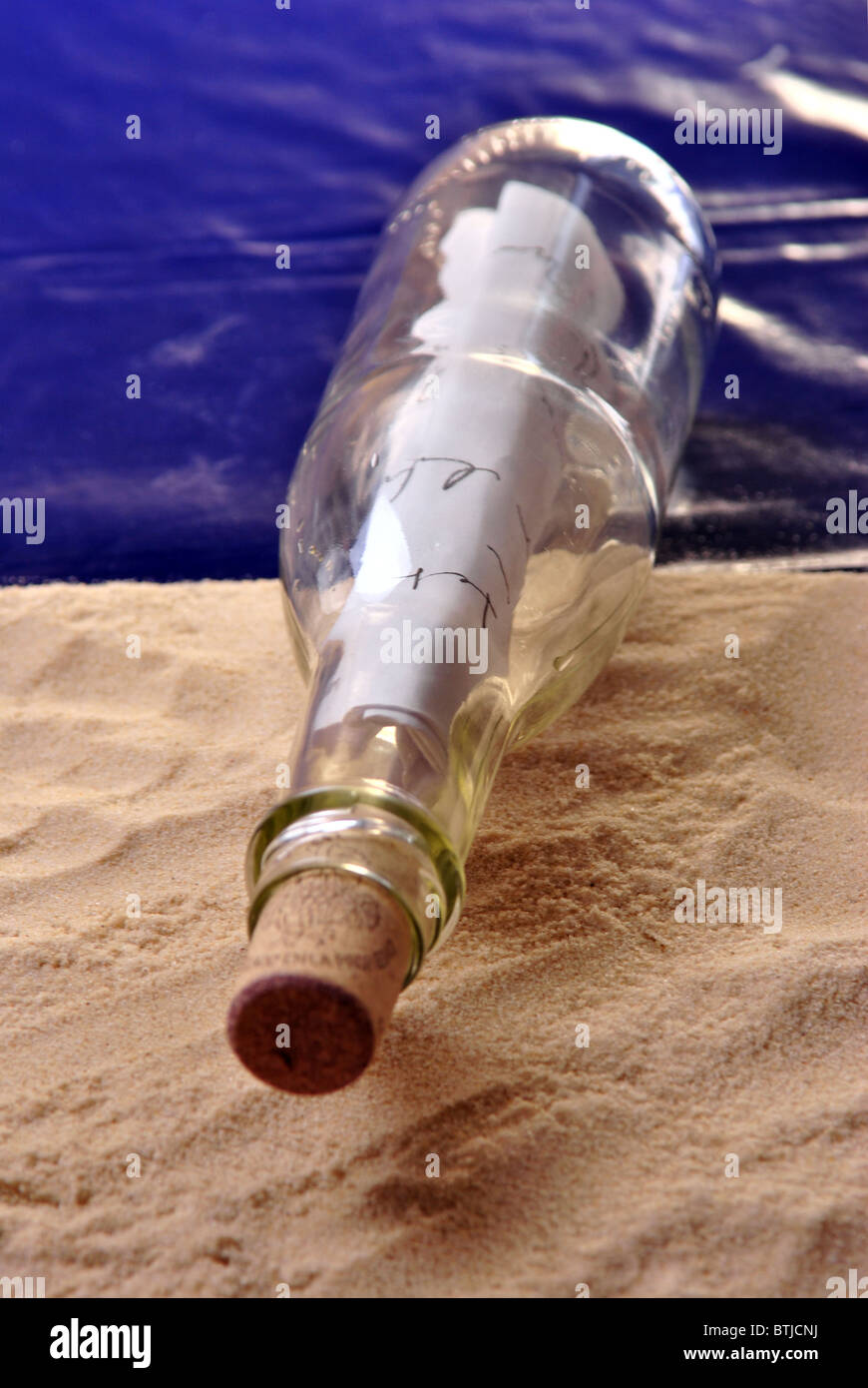 bottle message on a sandy beach with a letter Stock Photo - Alamy