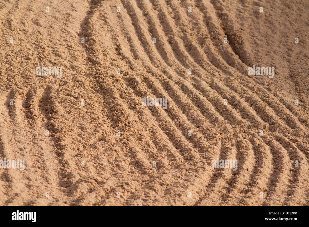Sand Trap rake pattern in the sand Stock Photo - Alamy