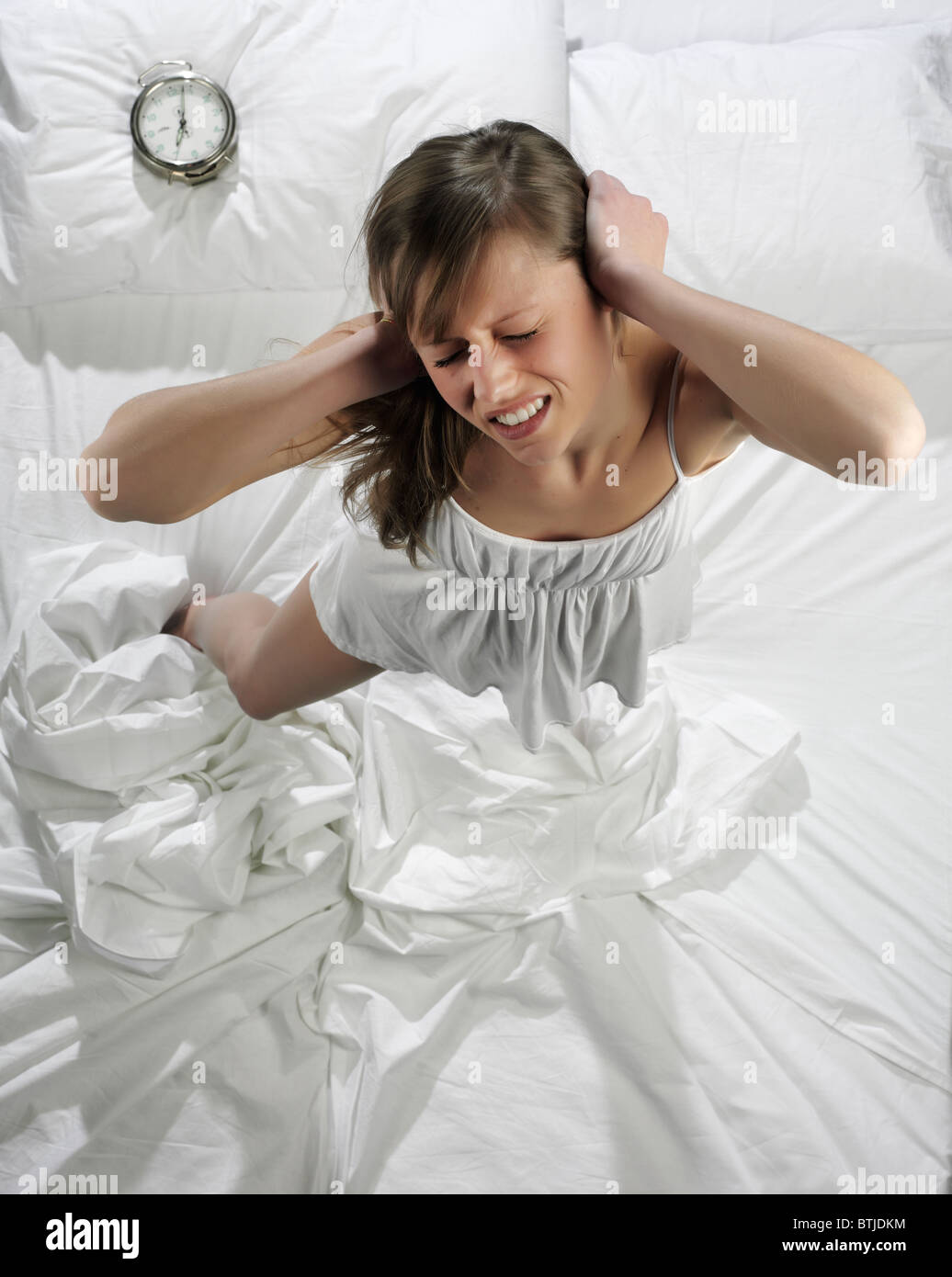 Woman in bed with alarm clock Stock Photo - Alamy