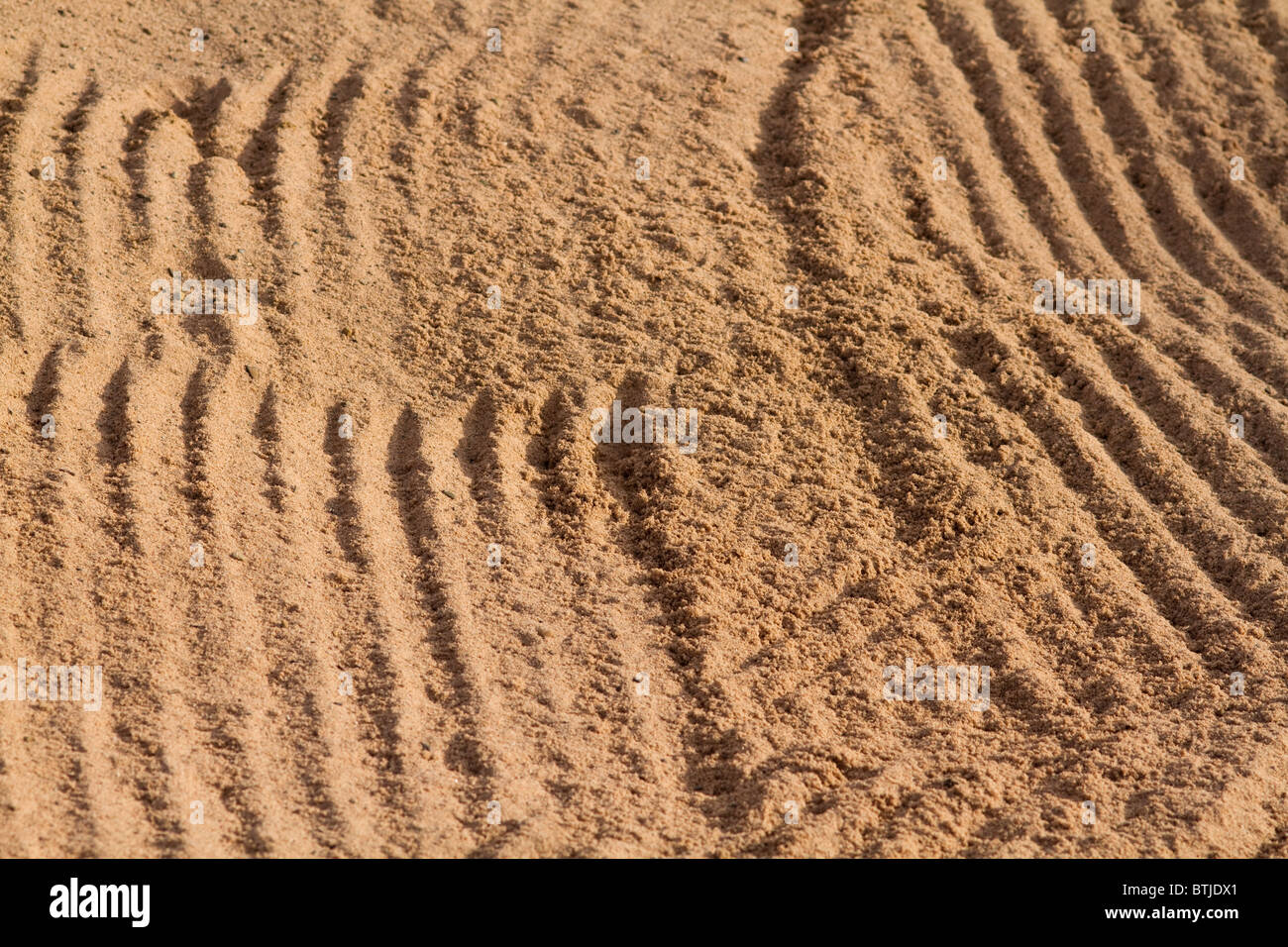 Sand Trap rake pattern in the sand Stock Photo - Alamy