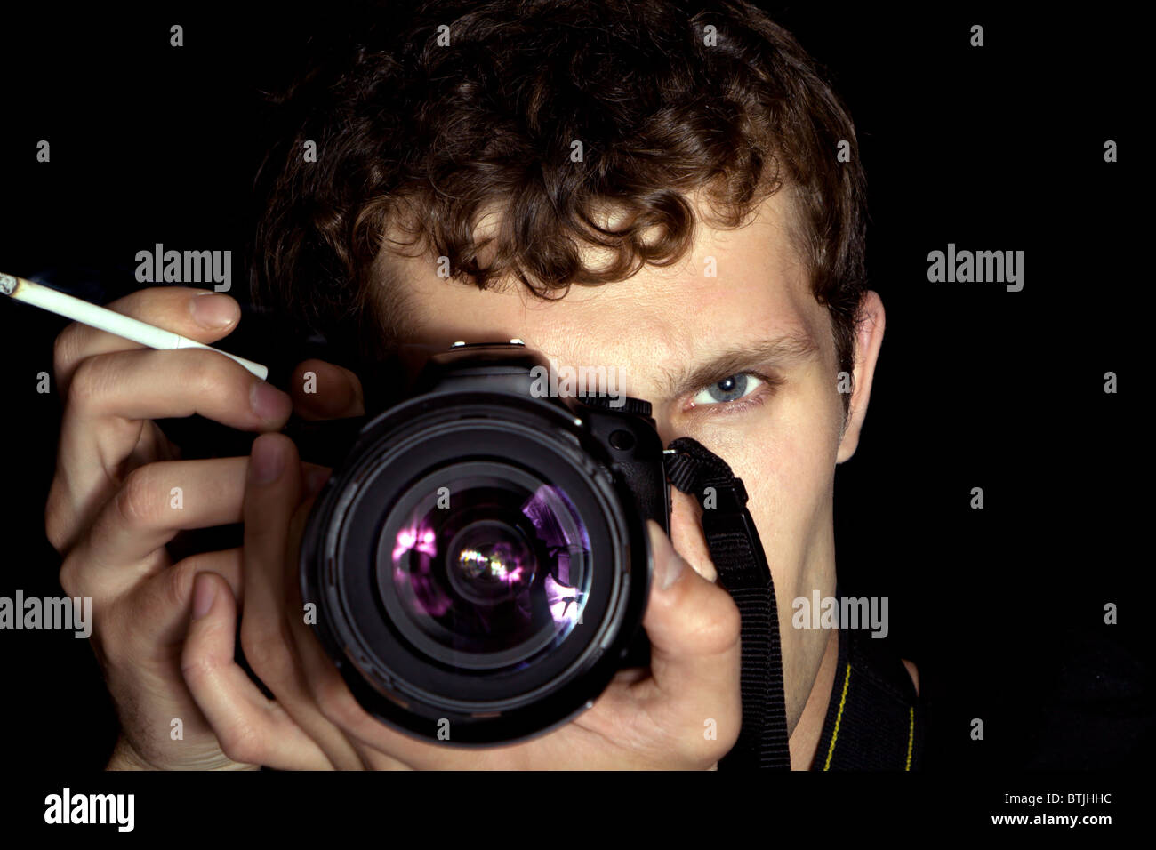 The young man - photographer behind work. Isolated on a black ...