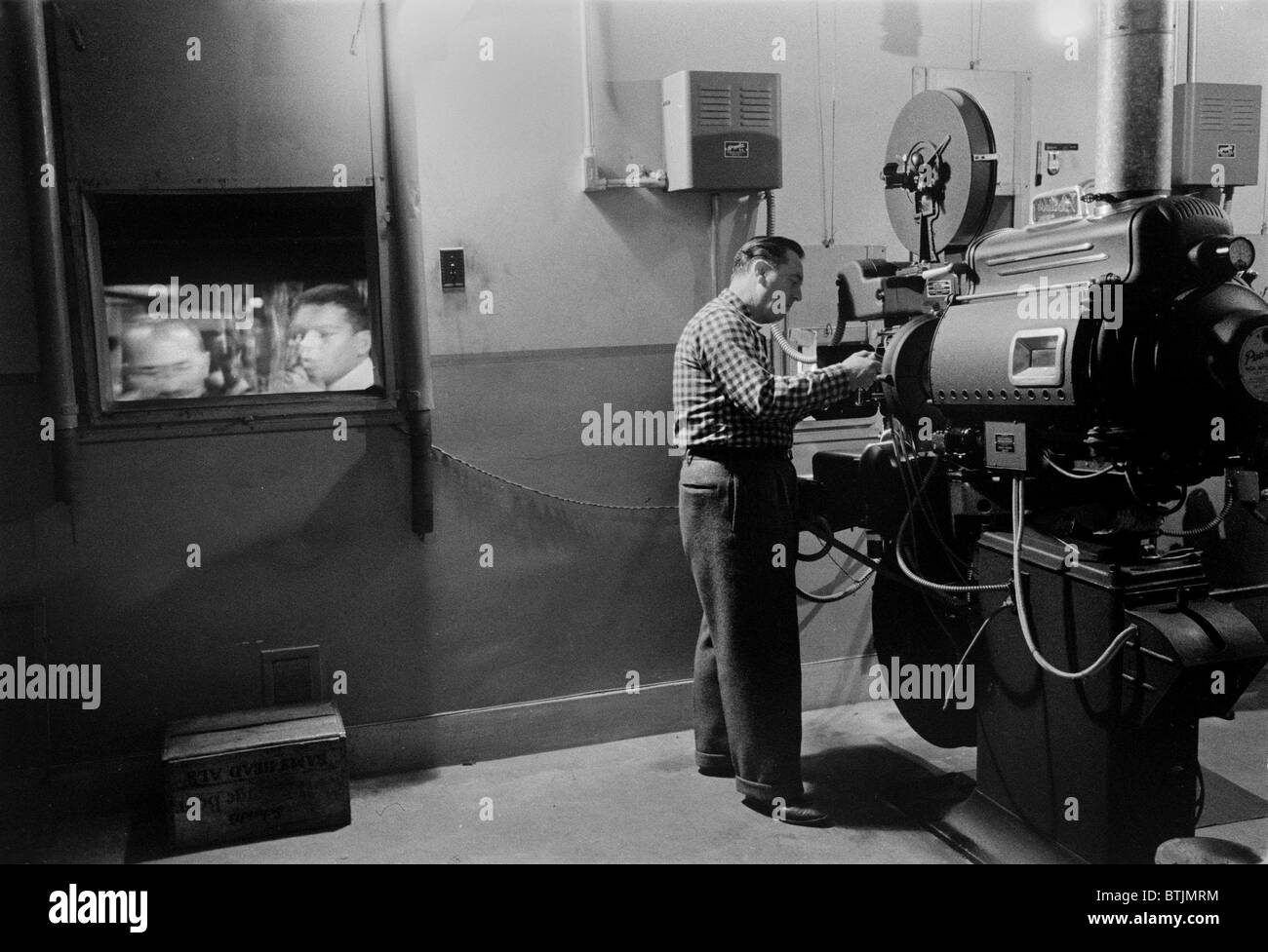 Man working a projector in a movie theater, photo by Marion S. Trikosko ...