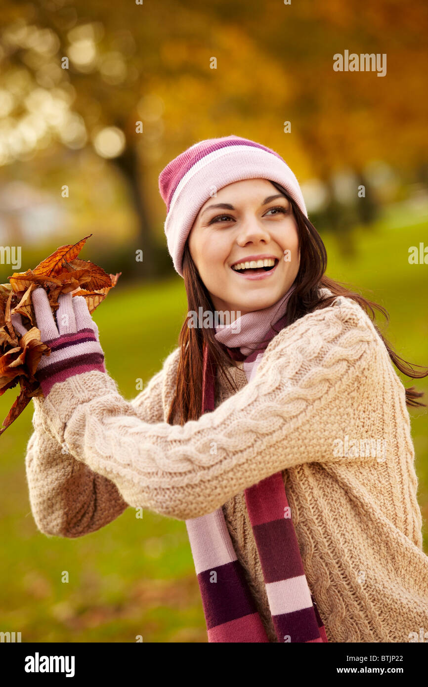 Brunette girl collecting Autumn leaves Stock Photo - Alamy