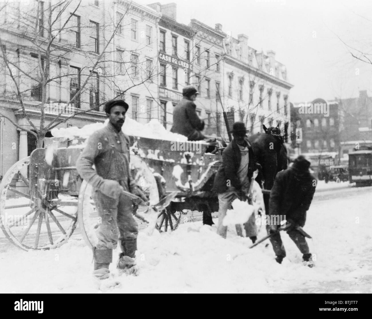 African American men loading snow onto wagon, after a 1915 snow storm ...