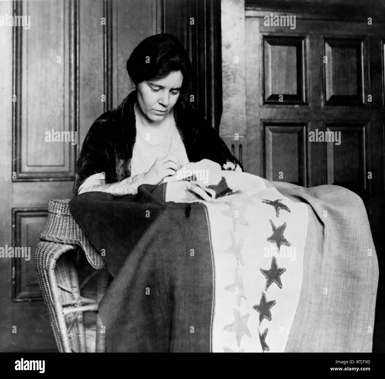 Alice Paul (1885-1977) sewing another star onto the "Suffrage Flag," after another state ...