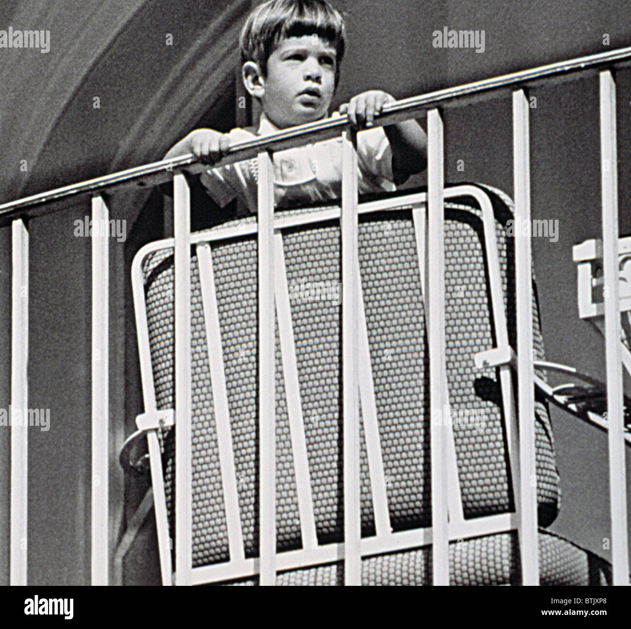 JOHN F. KENNEDY Jr., watches a ceremony from a balcony at the White ...