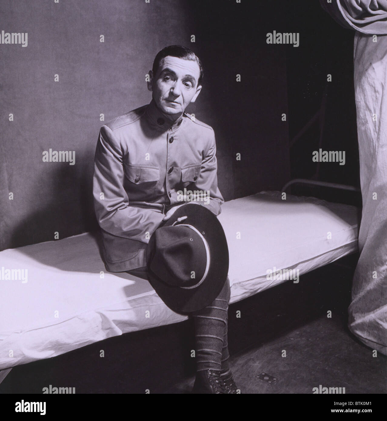 Irving Berlin (1888-1989) in WWI army uniform and seated on cot. In ...