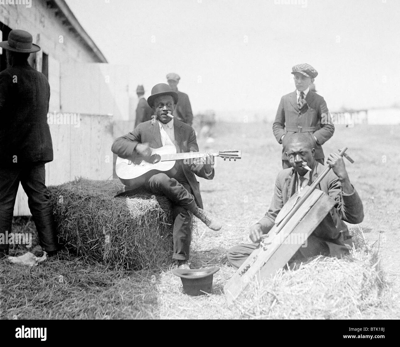 Folk Music. Two musicians sitting on bales of hay and playing ...