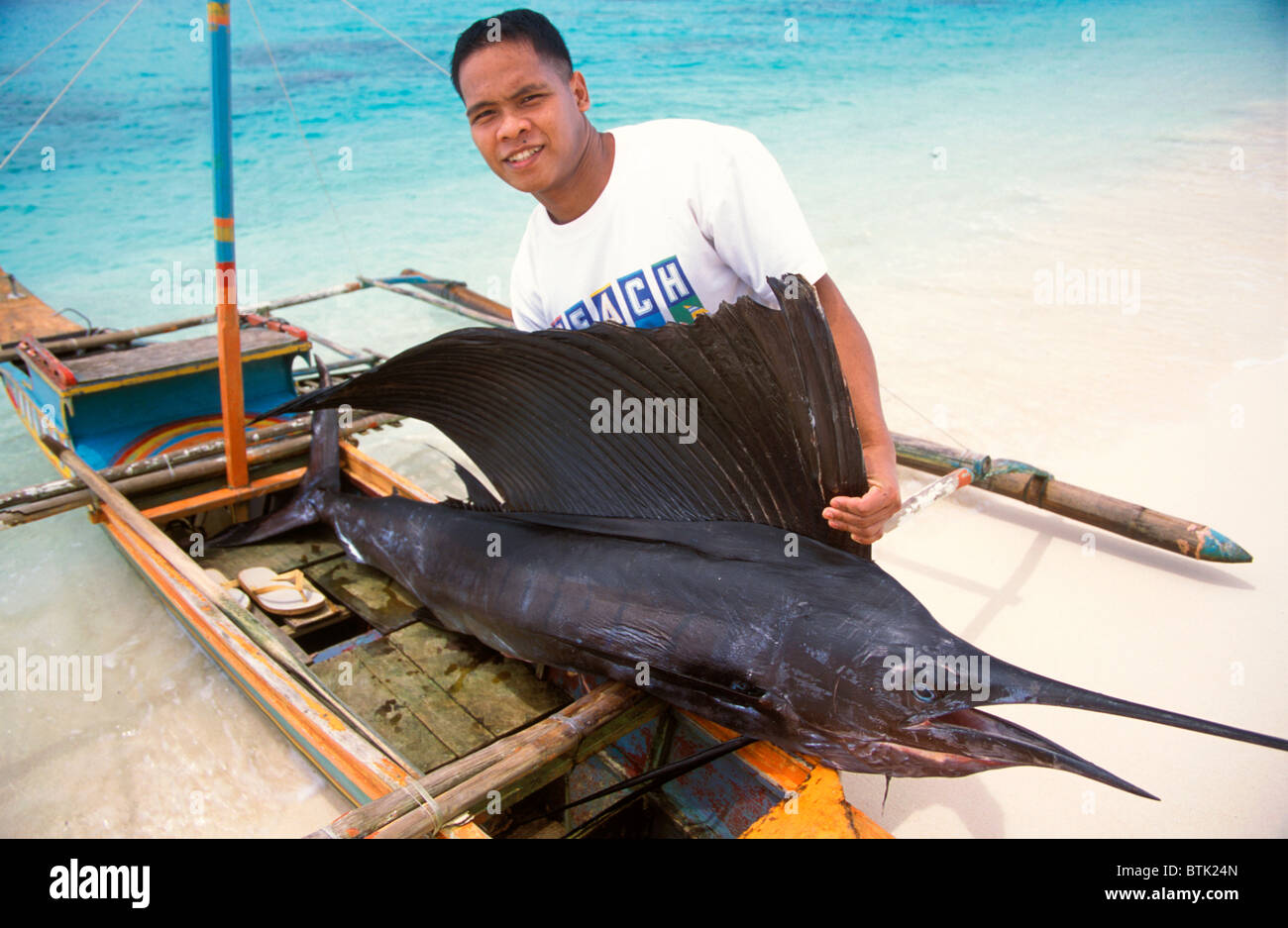 A man displays a marlin fish caught by a small fisherman working from a ...