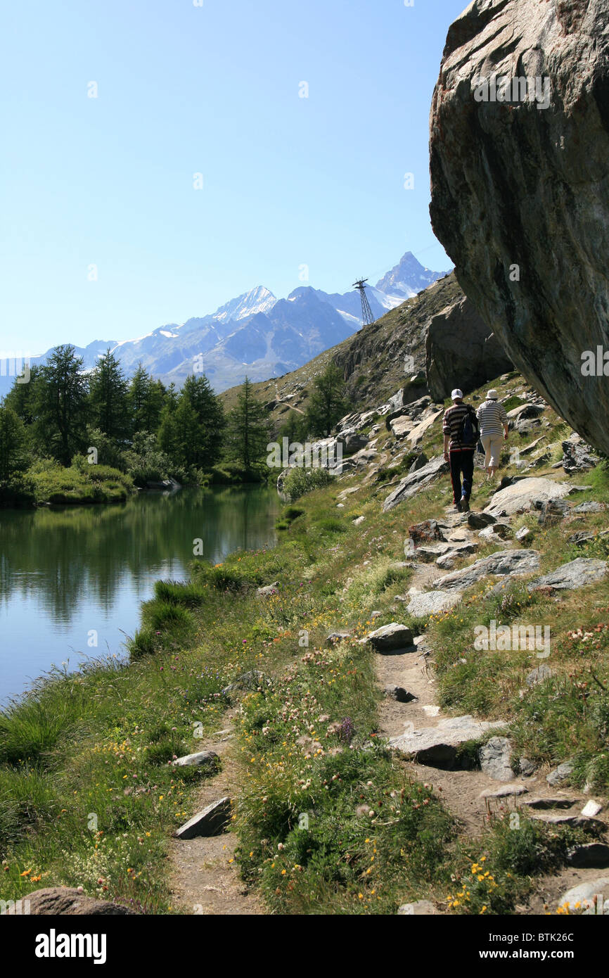 Man walking along path in swiss alps mountains. Zermatt, the canton of ...