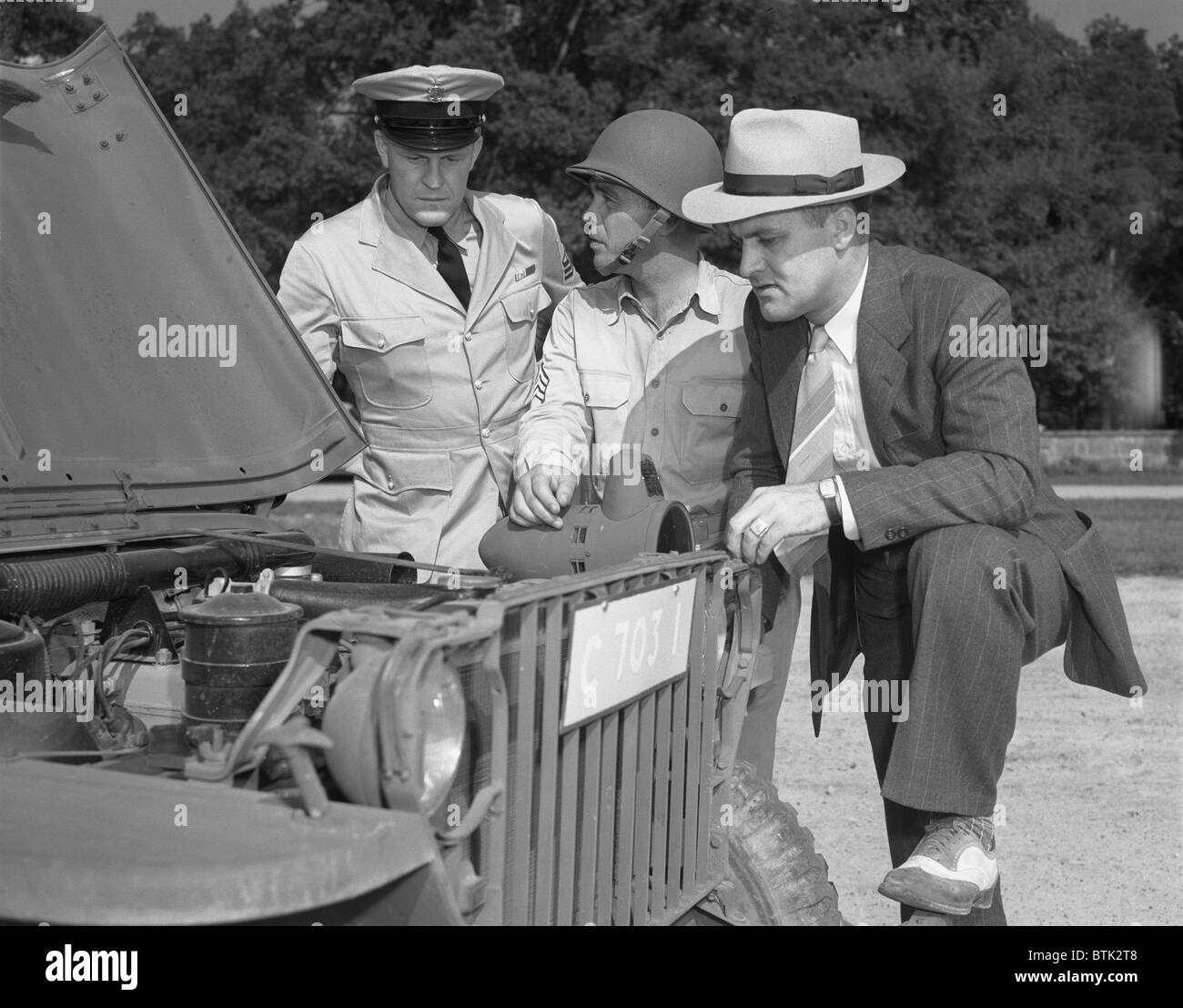 World War II, George Woolslayer (right) examining an army jeep at the ...