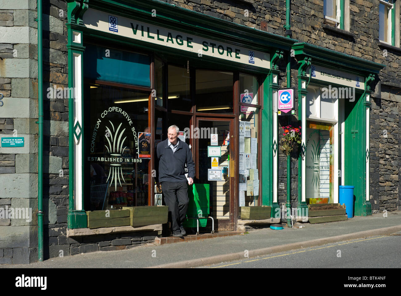 Man leaving the Village Store in Coniston, Lake District National Park ...