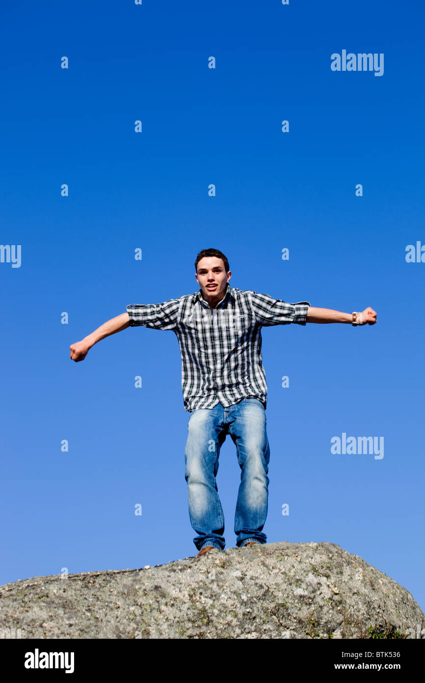 young happy man, starting a big jump, on top of a rock Stock Photo - Alamy