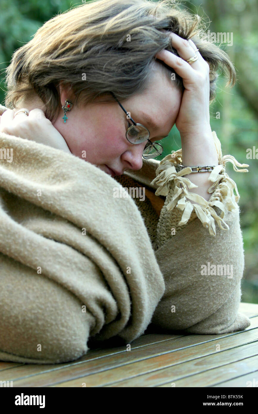 Mature woman looking down sorrow hi-res stock photography and images ...