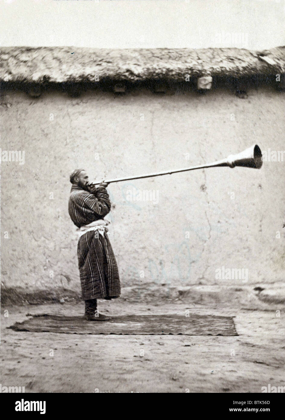 Central Asian man playing a long necked Uzbek instrument called a ...