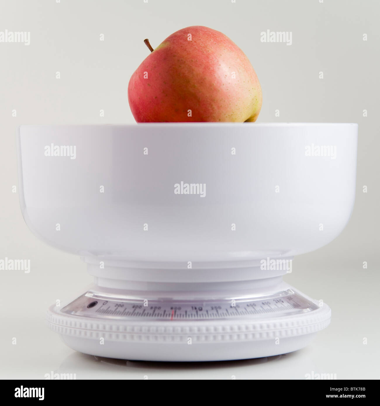 apple in a kitchen scale Stock Photo - Alamy