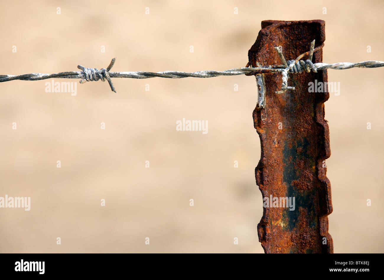 rusty pole with barb wire Stock Photo - Alamy