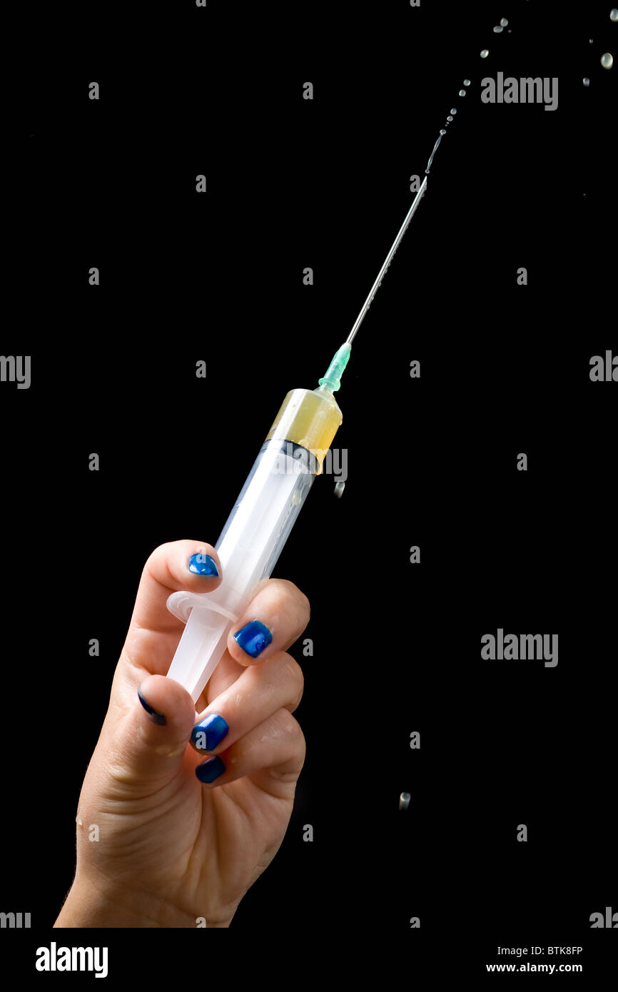 Hand holding syringe with needle Stock Photo - Alamy