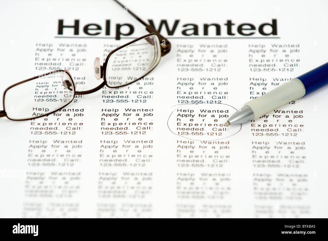 Help wanted paper with job circled with glasses and pen Stock Photo - Alamy