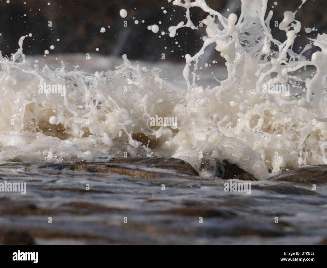 Bubbles of foam at the front of a wave hitting the shore, UK Stock ...