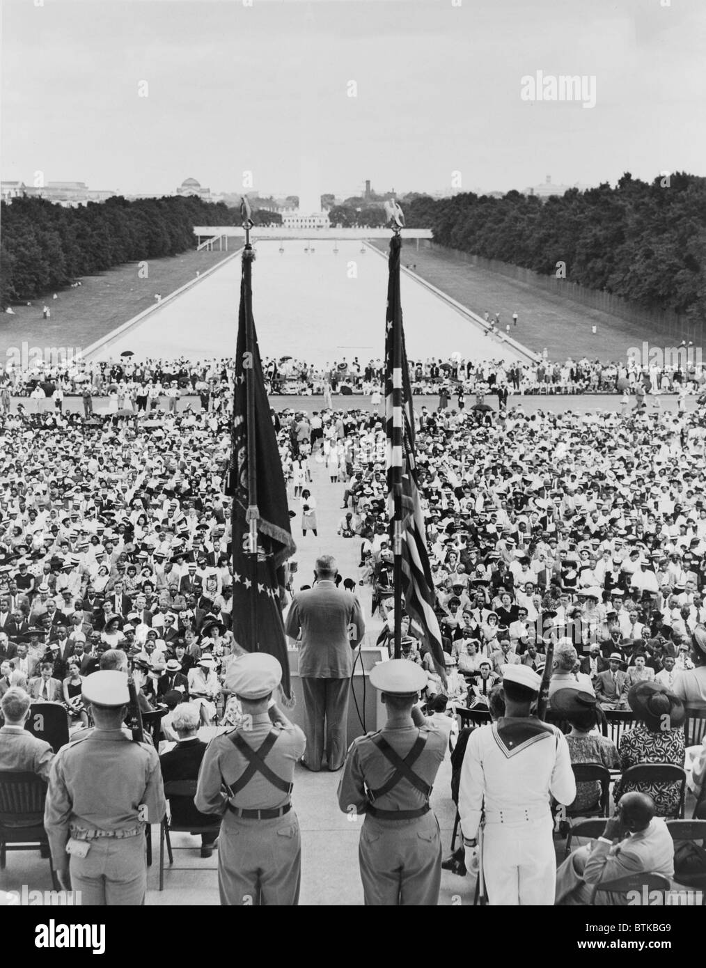 President Harry S. Truman (between flags) speaks the steps of the ...
