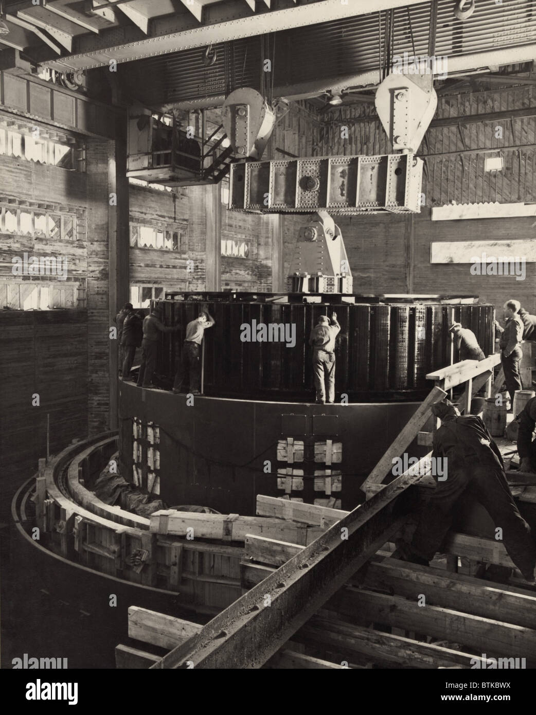 Workmen installing a generator in the Norris Dam powerhouse. Norris Dam ...