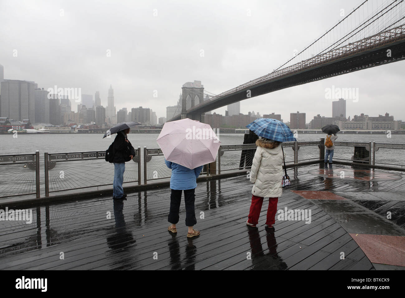 Tourists looking at the Manhattan skyline in the rain, New York City ...