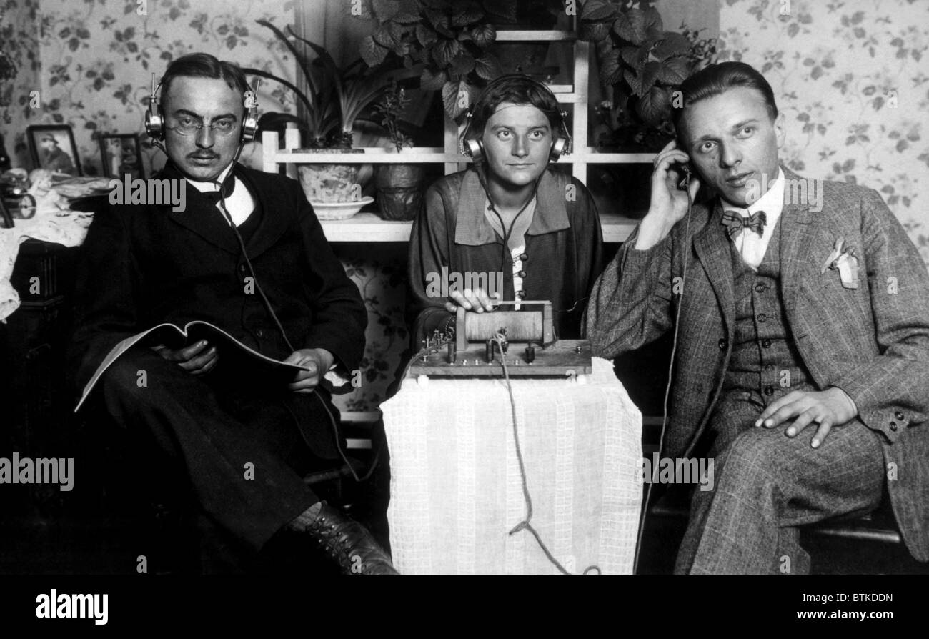 Three people listening to an early radio, c. 1925 Stock Photo - Alamy