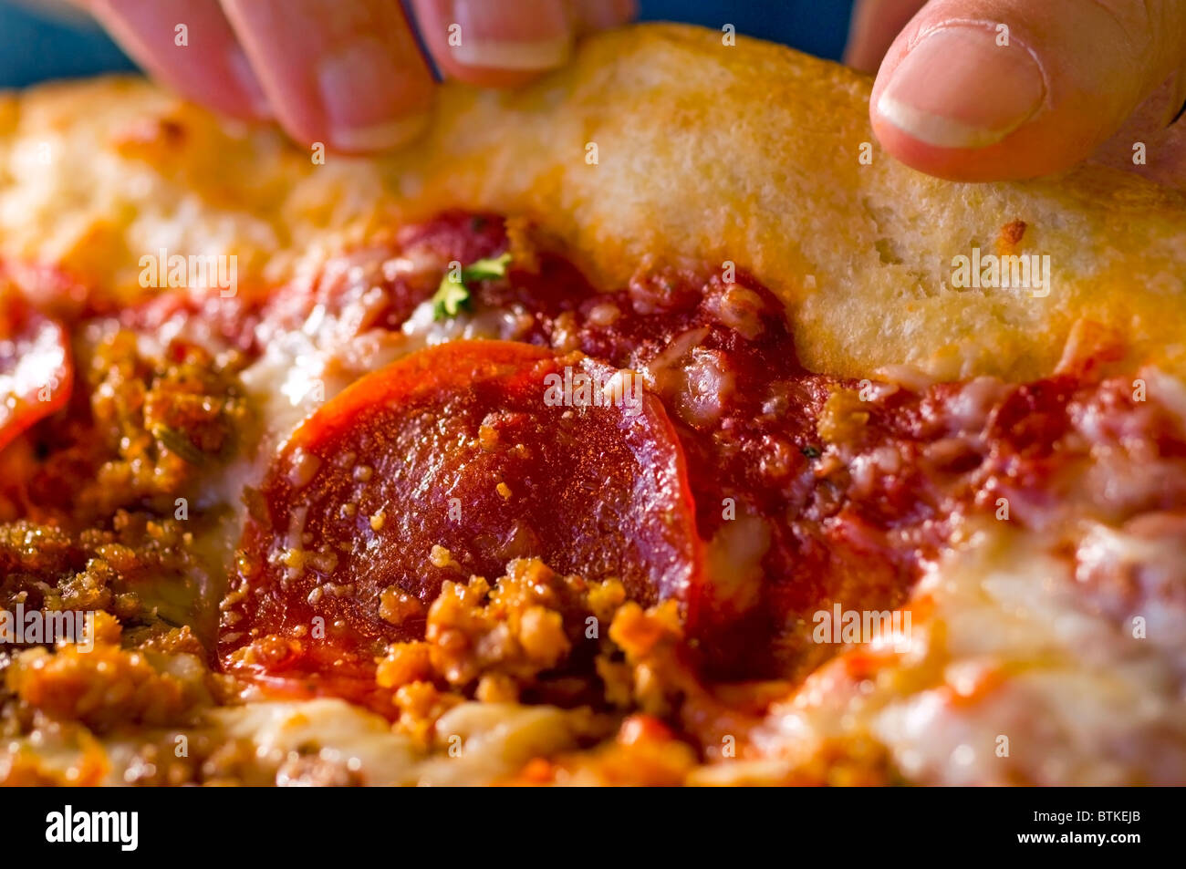 Two female hands tearing off slice of pizza Stock Photo - Alamy