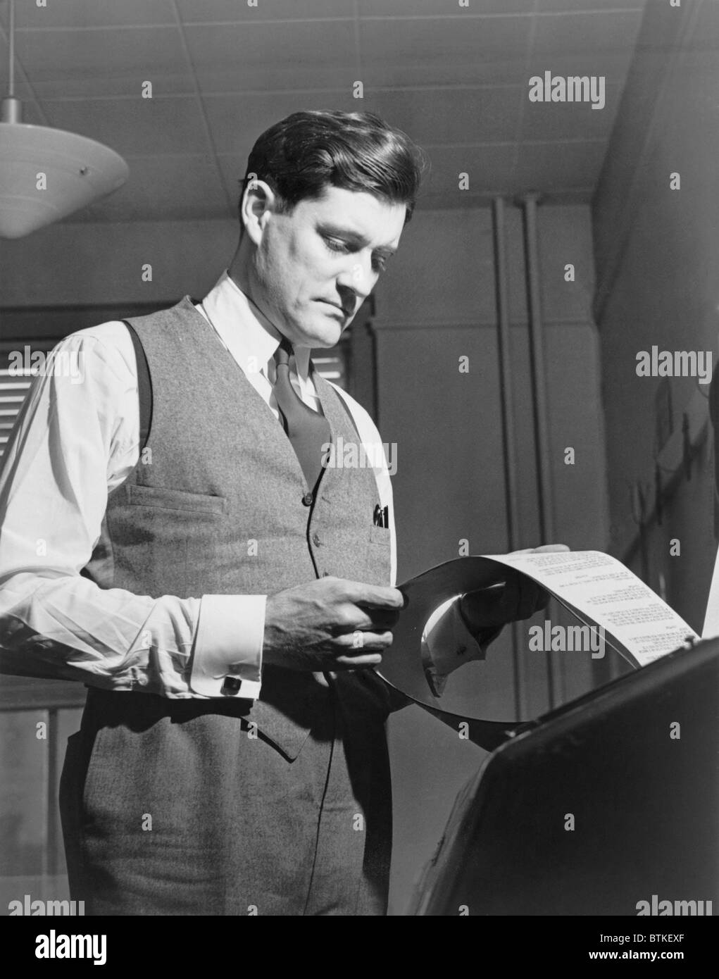 Eric Sevareid (1912-1992), reads document from teletype. He was one of ...