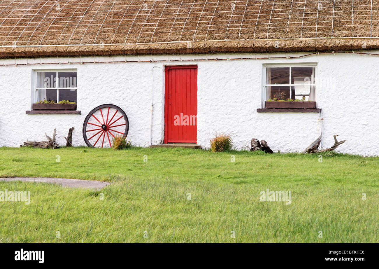 A thatched cottage with a red door at the Glencolmcille Folk Village ...