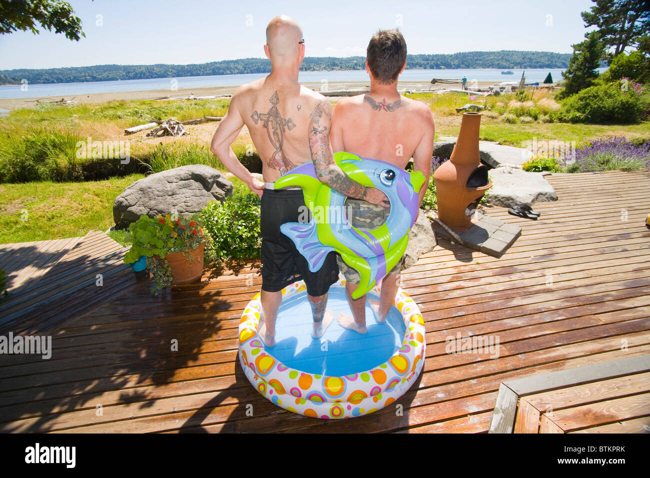 tattoed men in wading pool near beach Stock Photo - Alamy